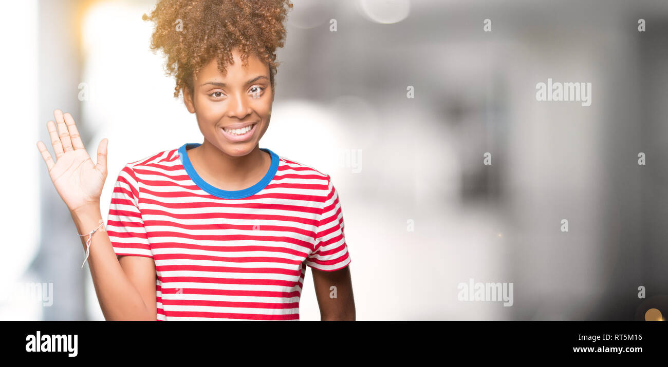 Beautiful young african american woman over isolated background Waiving ...