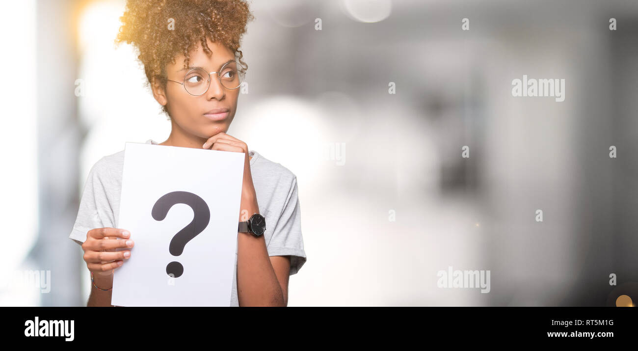Young african american woman holding paper with question mark over ...