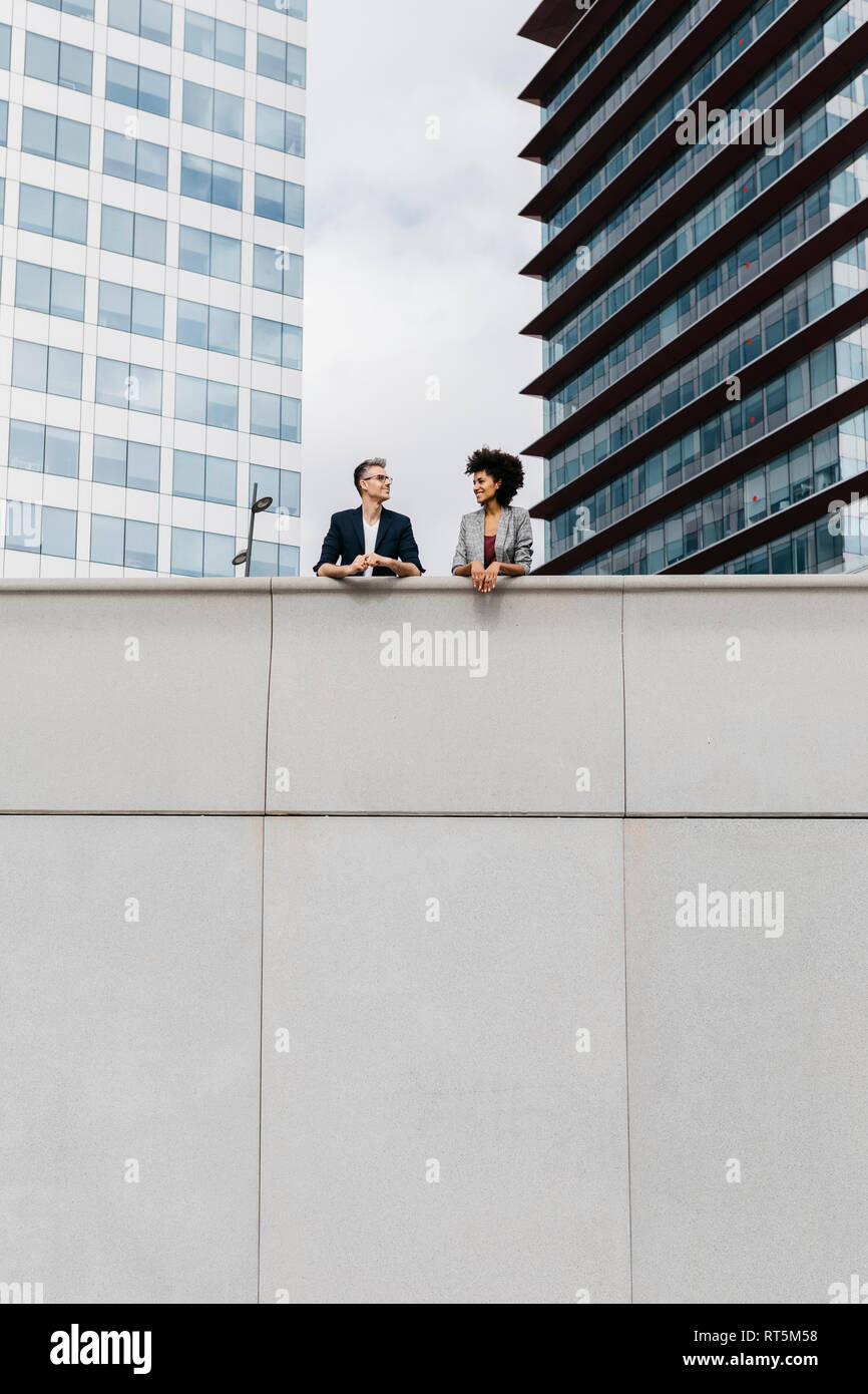 Two colleagues talking outside office building Stock Photo - Alamy