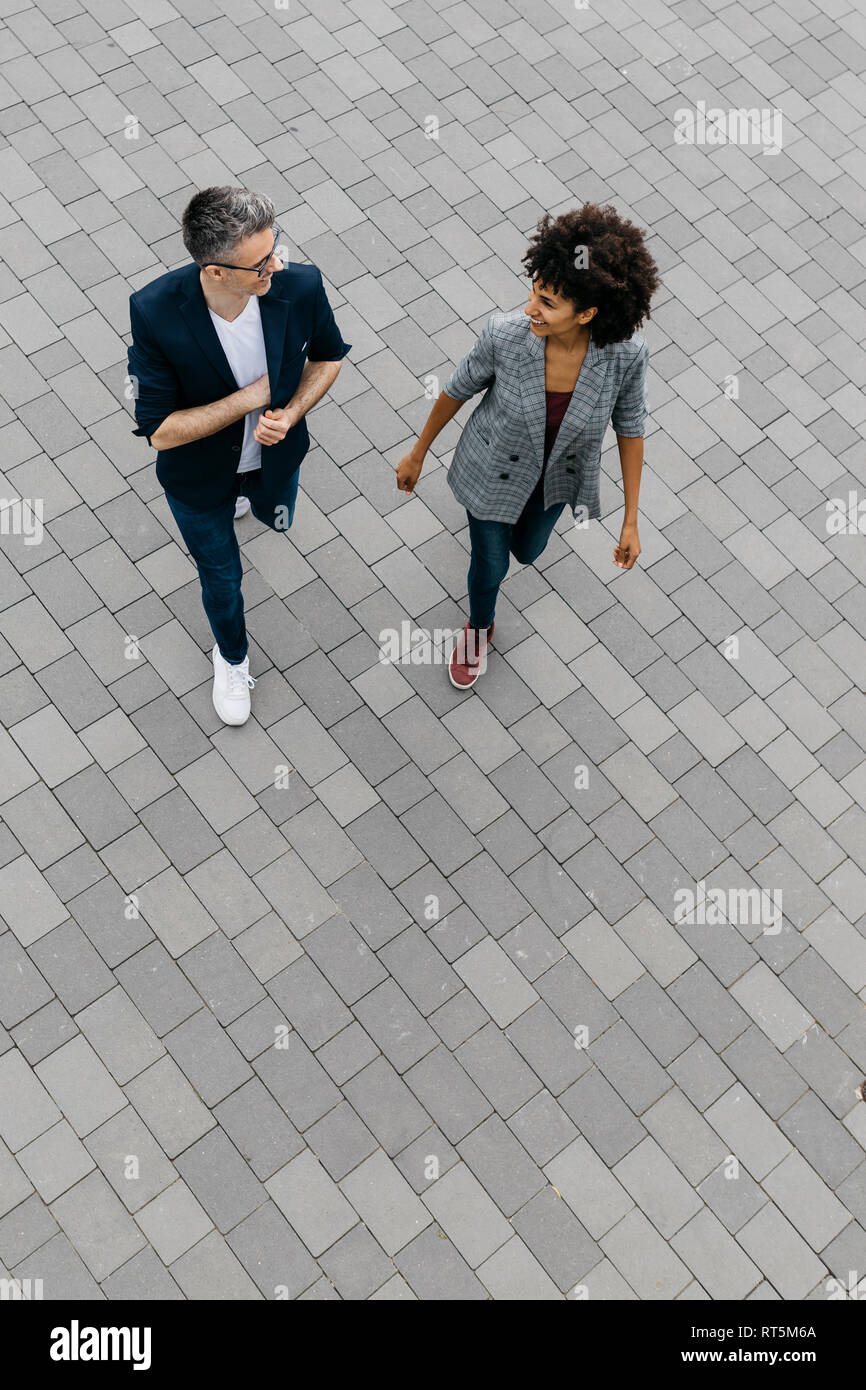 Top view of two colleagues walking and talking on a square Stock Photo ...