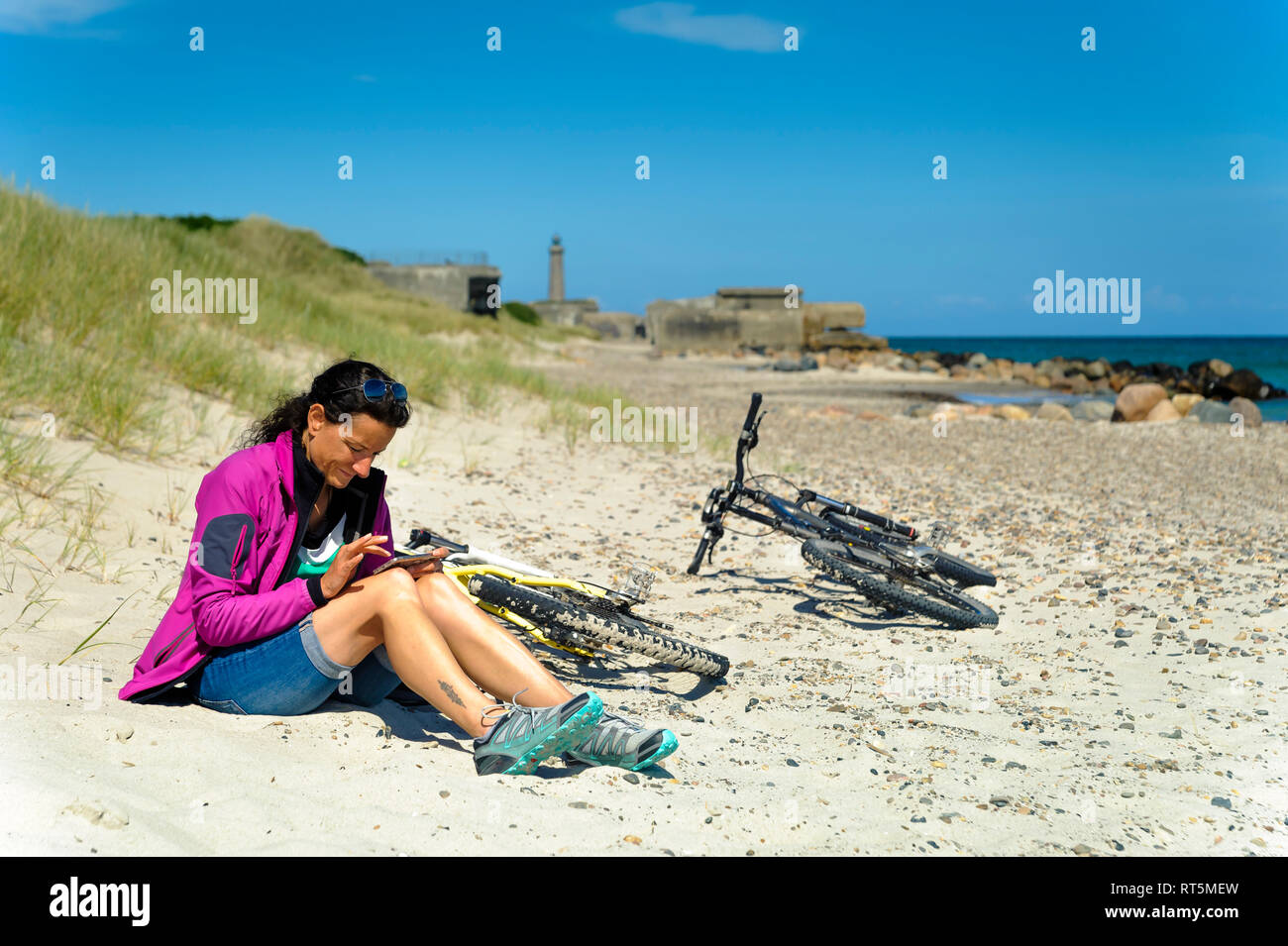Denmark, Jutland, Skagen, Grenen, woman sitting on the beach next to ...
