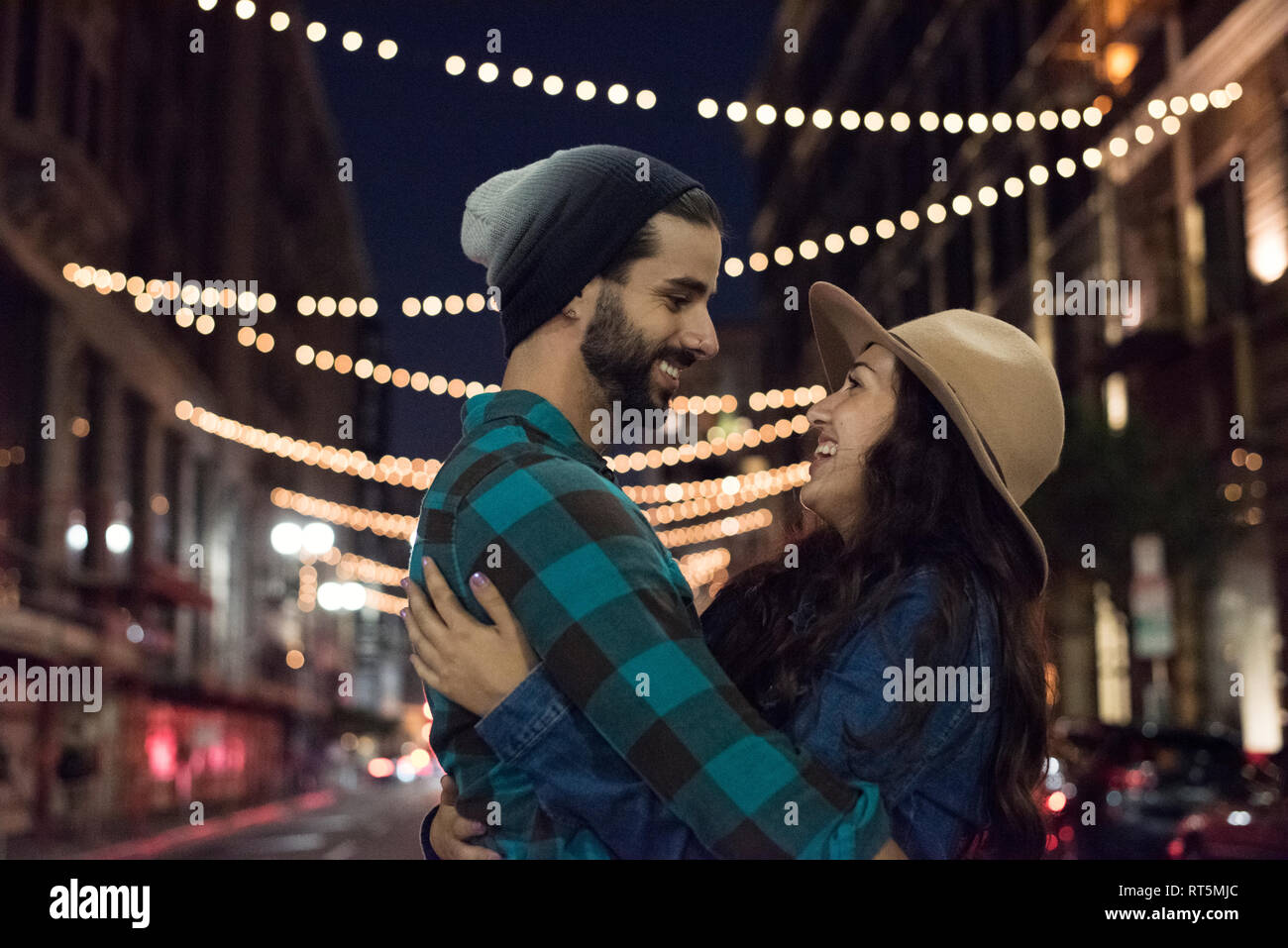 Happy young couple hugging on the steet at night Stock Photo - Alamy