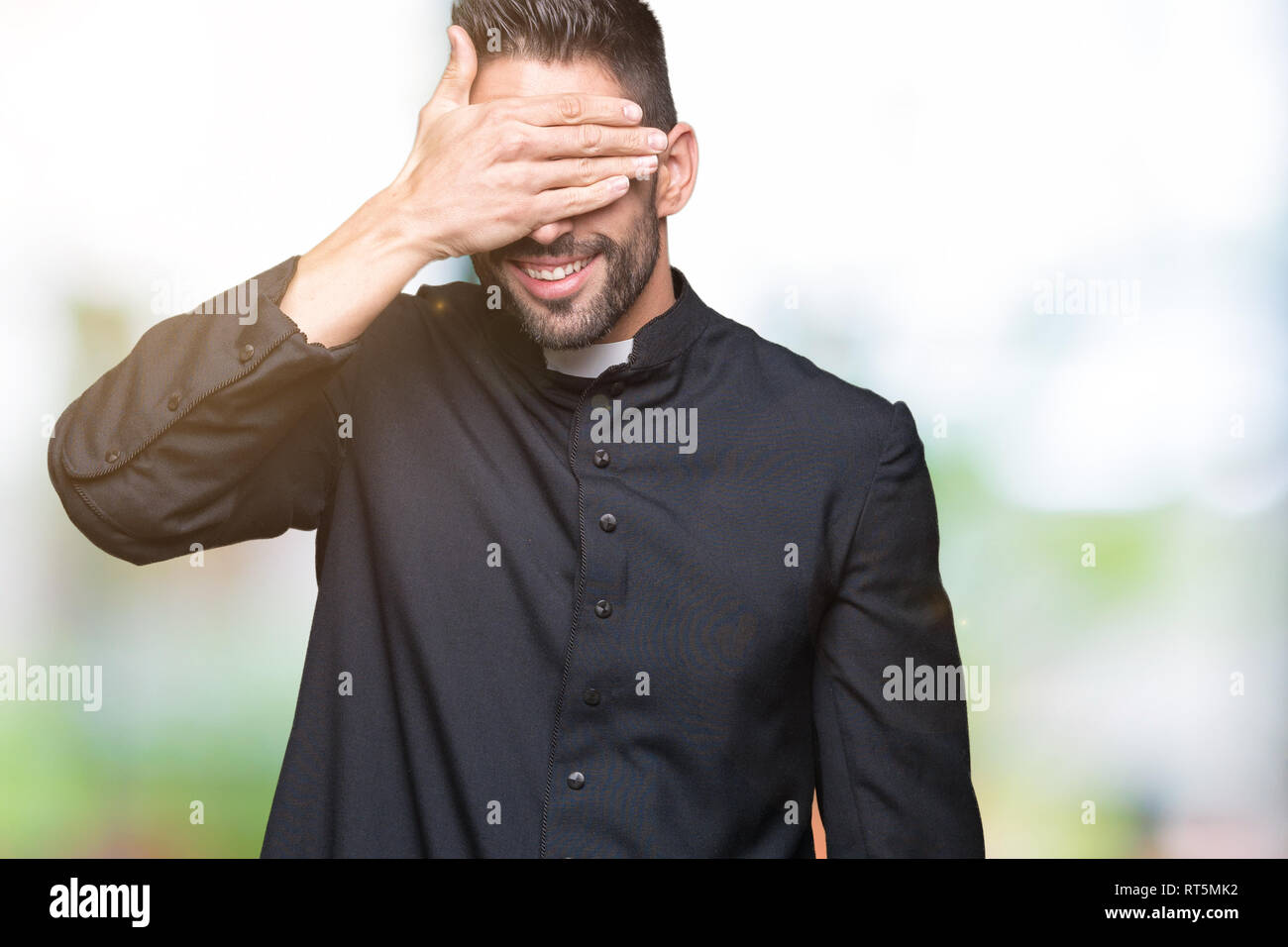 Young Christian priest over isolated background smiling and laughing ...