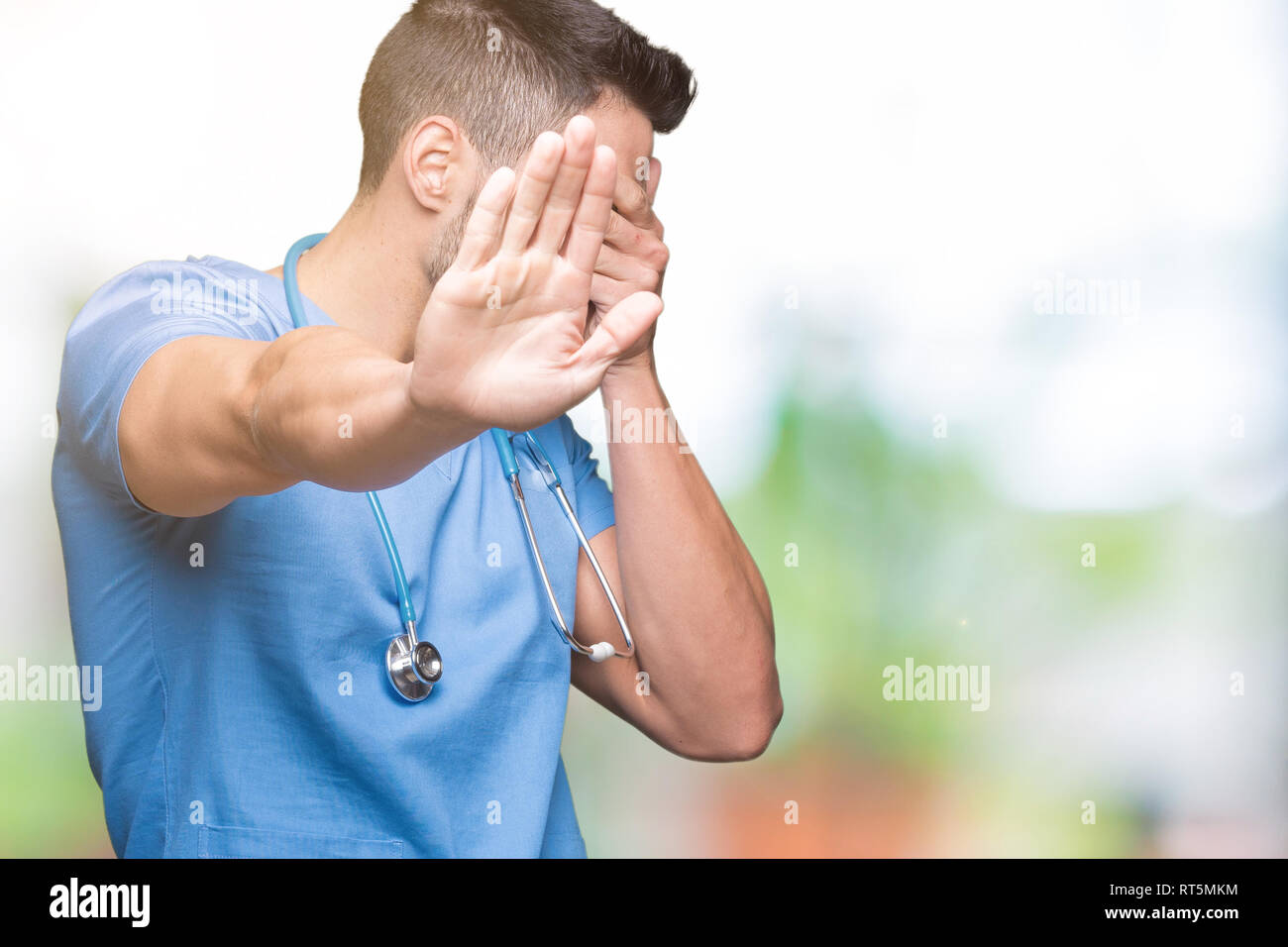 Handsome young doctor surgeon man over isolated background covering ...