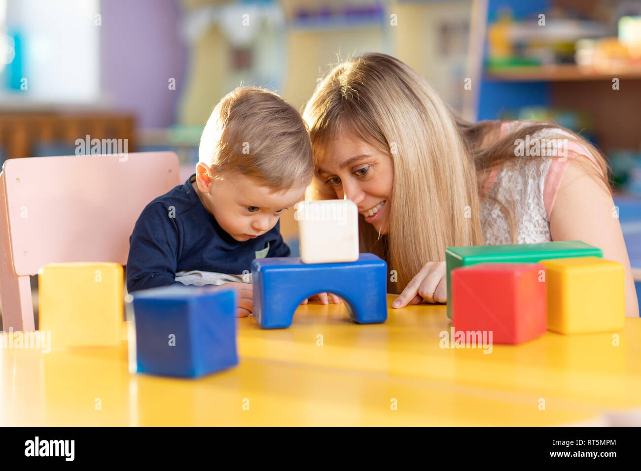Curious baby and kindergartener playing developmental block toys Stock ...