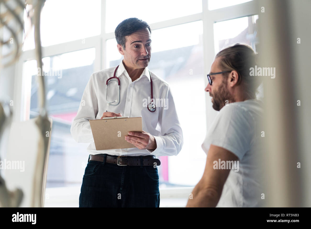 Doctor talking to patient in medical practice Stock Photo - Alamy