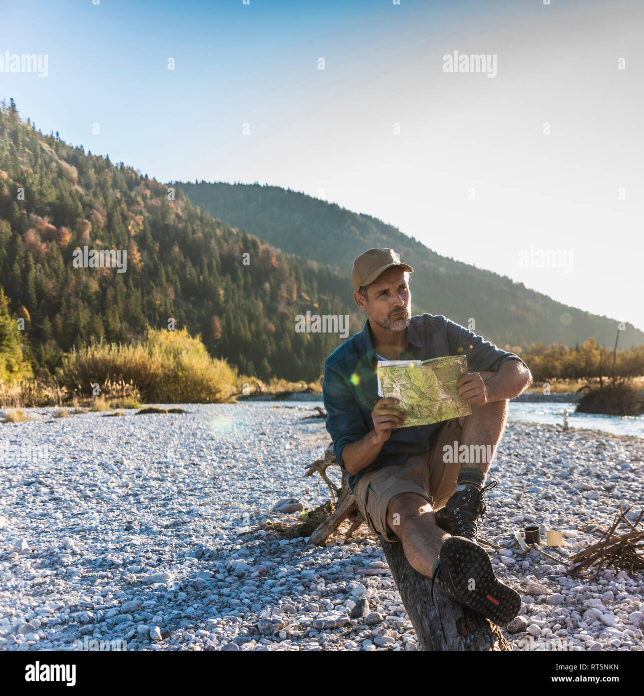 Mature man with map at riverside Stock Photo - Alamy