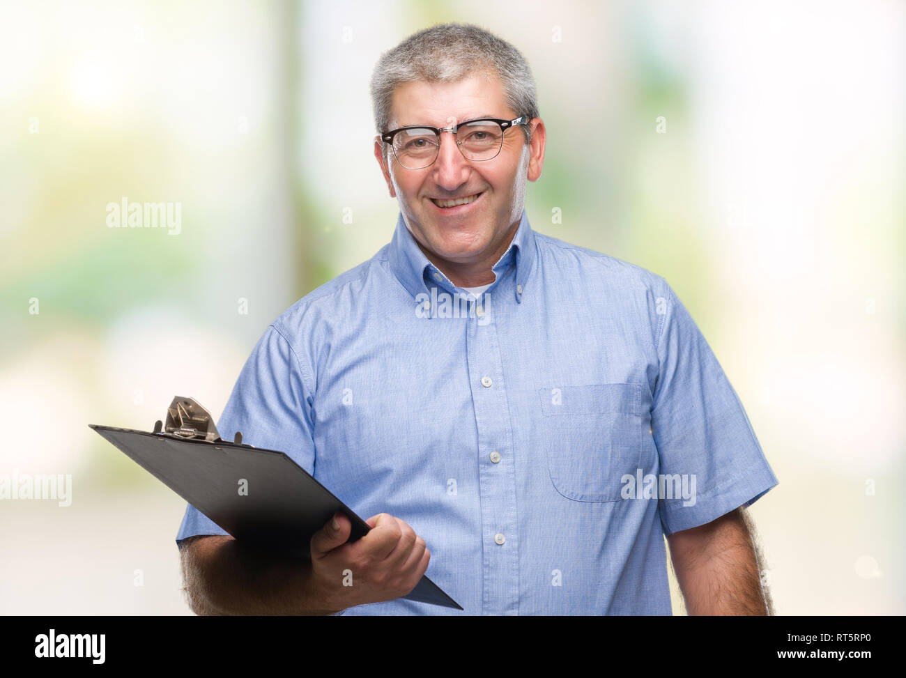 Handsome senior inspector man holding clipboard over isolated ...