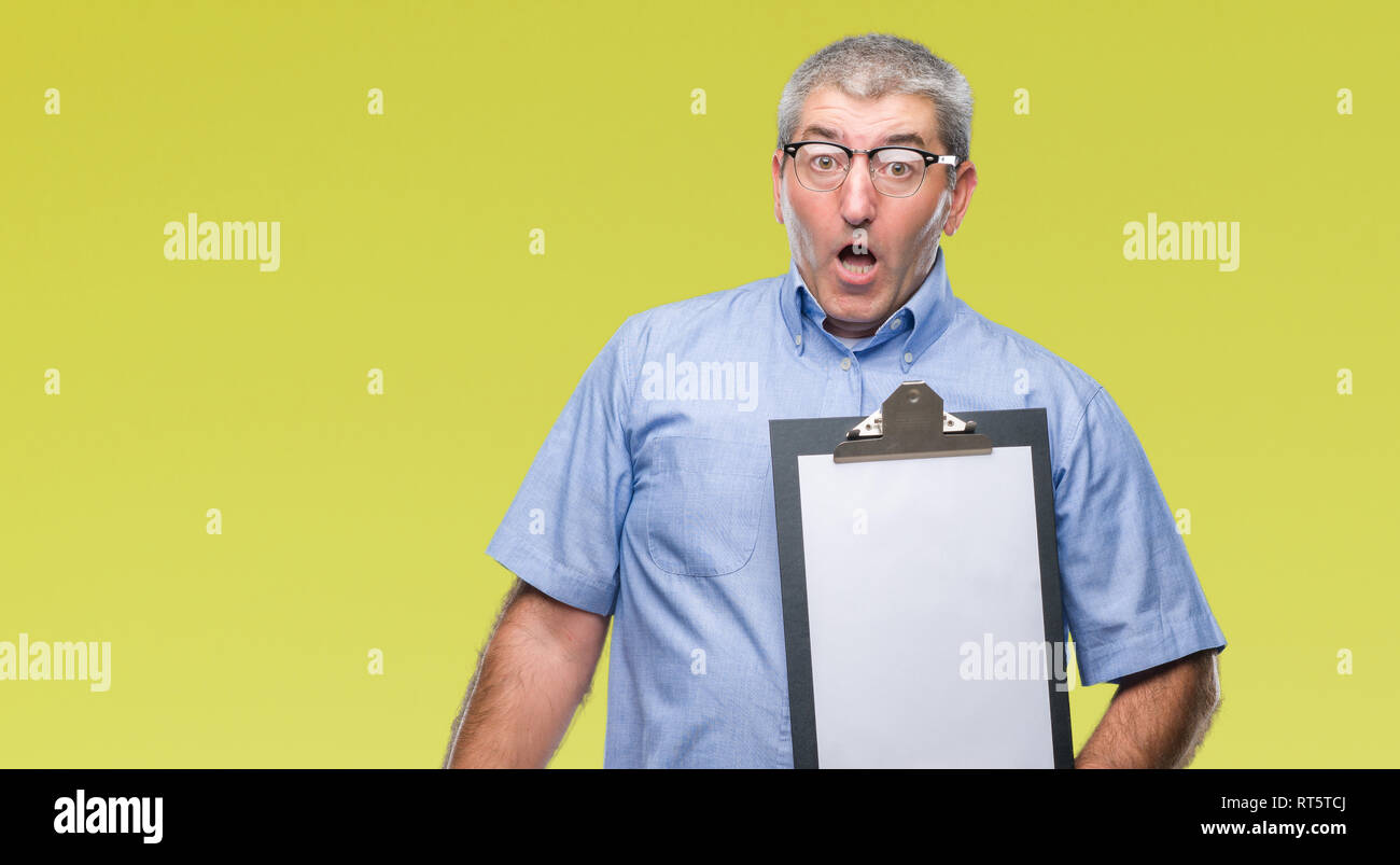 Handsome senior inspector man holding clipboard over isolated ...