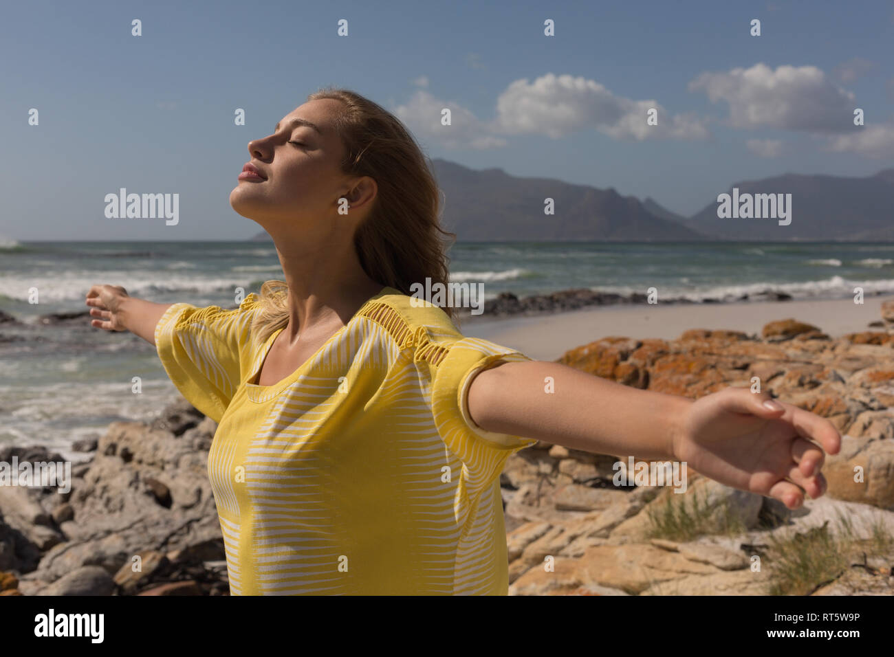 Woman standing with arms outstretched on the beach Stock Photo - Alamy