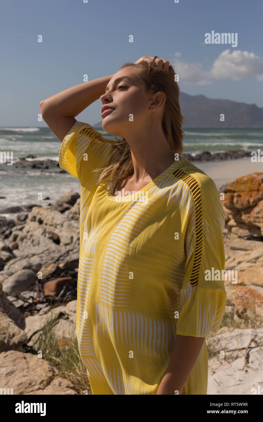 Woman standing on the rock at beach Stock Photo - Alamy