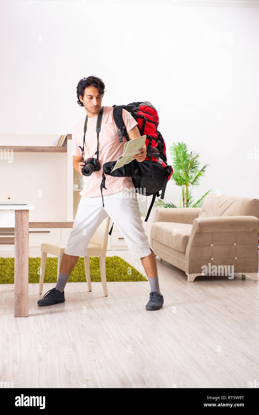 Young male tourist preparing for trip at home Stock Photo - Alamy
