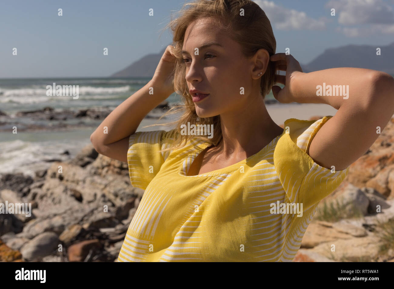 Woman standing on the rock at beach Stock Photo - Alamy