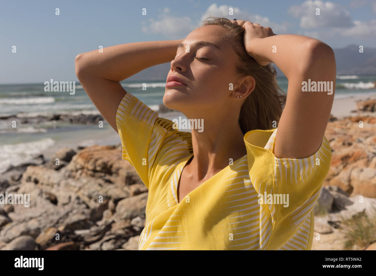 Woman standing on the rock at beach Stock Photo - Alamy