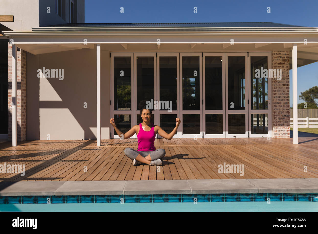 Woman performing yoga in the backyard of home Stock Photo - Alamy