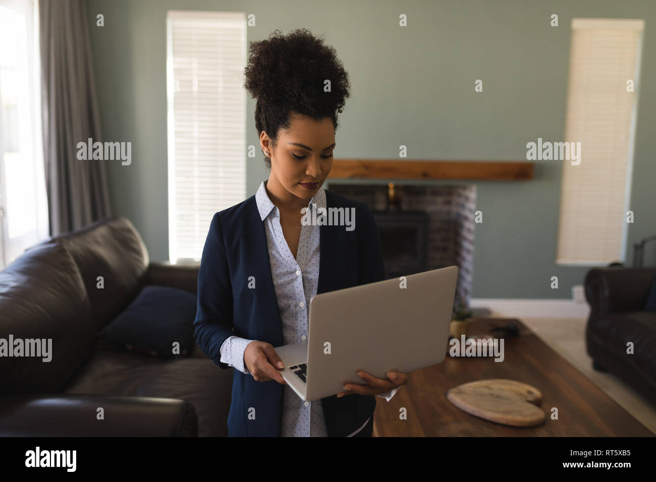 Female real estate agent using laptop at home Stock Photo - Alamy
