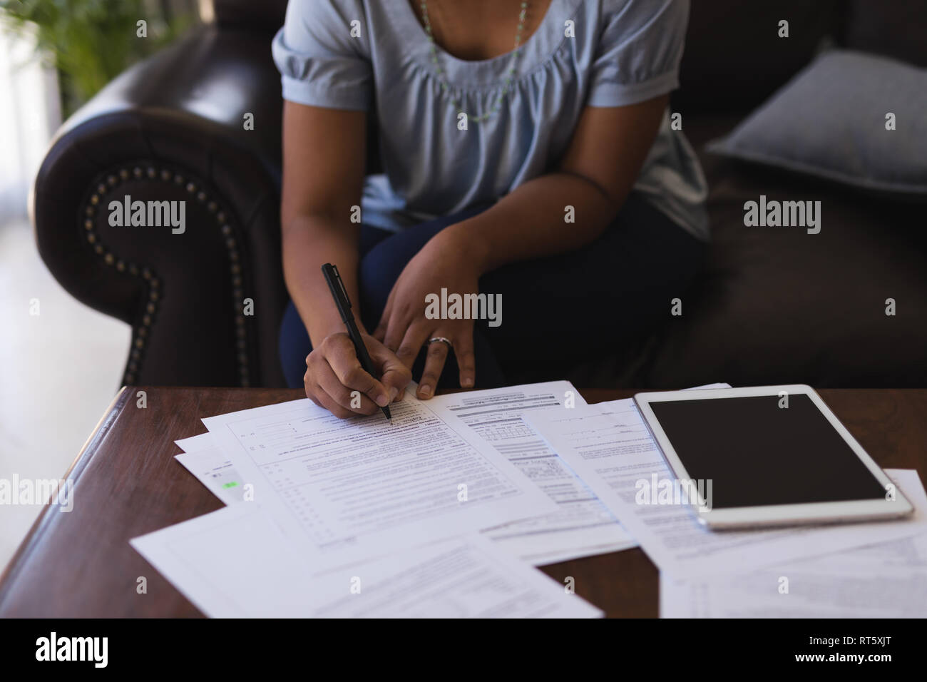 Woman filling form in living room at home Stock Photo - Alamy