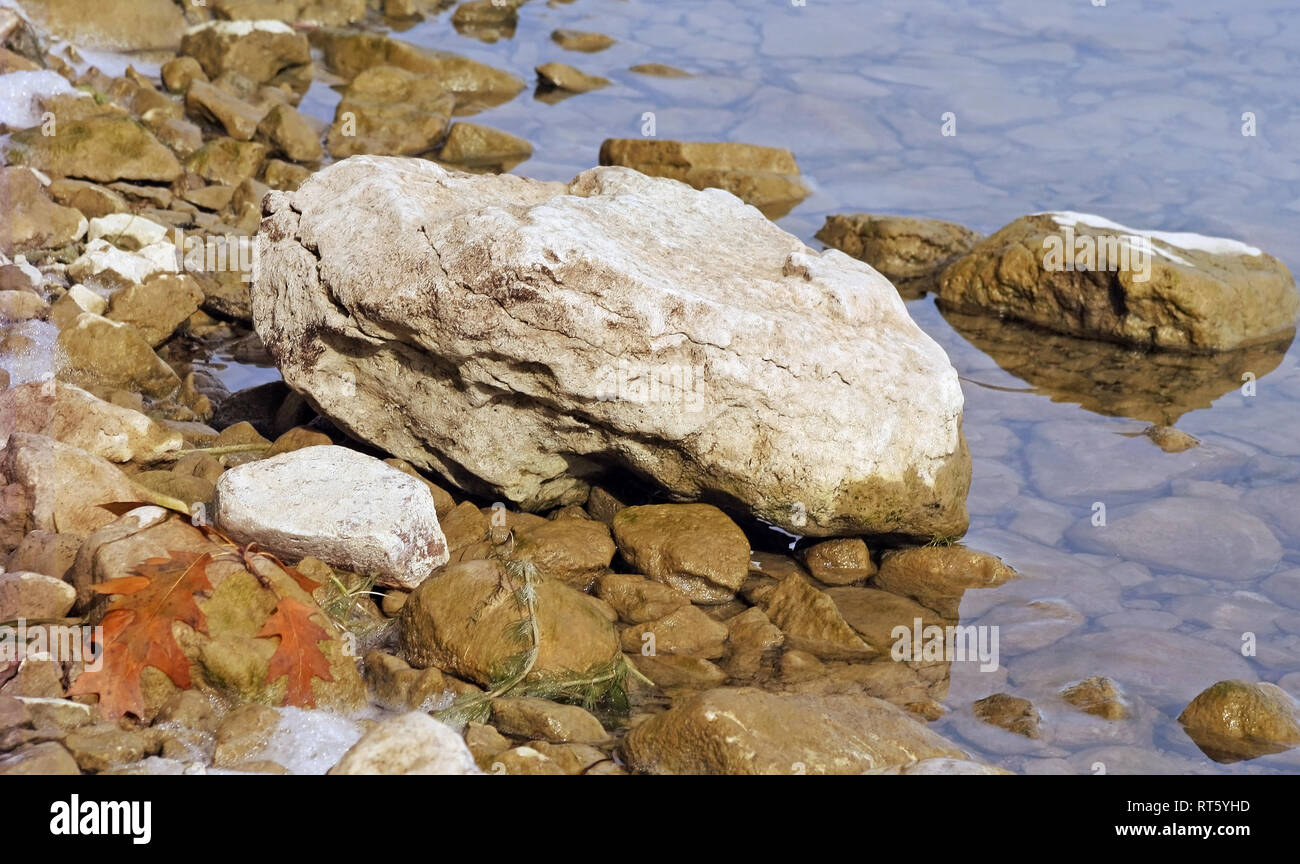 Large rocks and stones in shallow waters along lake shoreline Stock ...