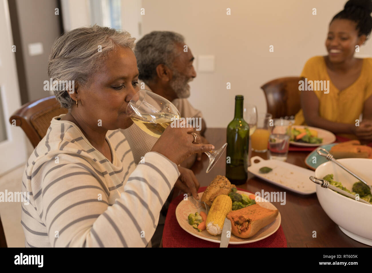 Multi-generation African American family eating dinner on dining table ...