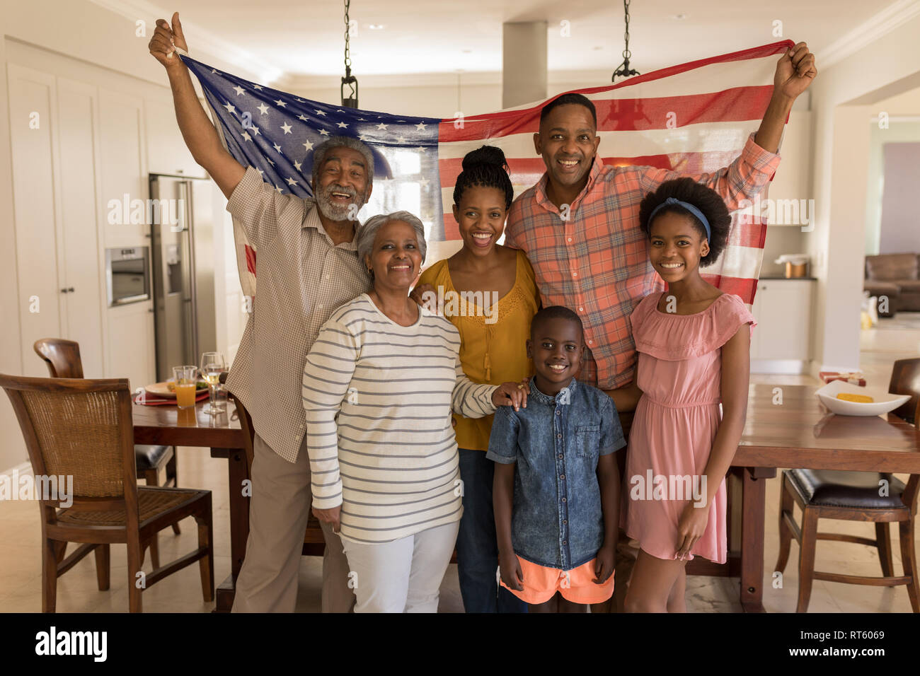 Multi-generation family holding an American flag at home Stock Photo ...