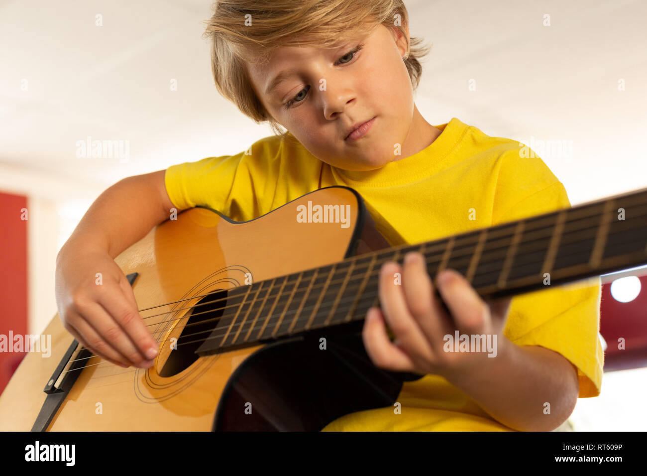 Boy playing guitar in a classroom Stock Photo - Alamy