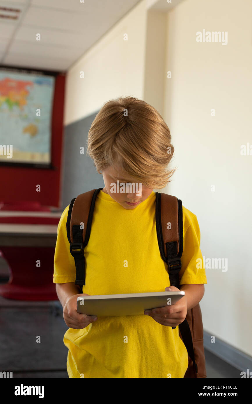 Boy with school bag using digital tablet in a classroom Stock Photo - Alamy