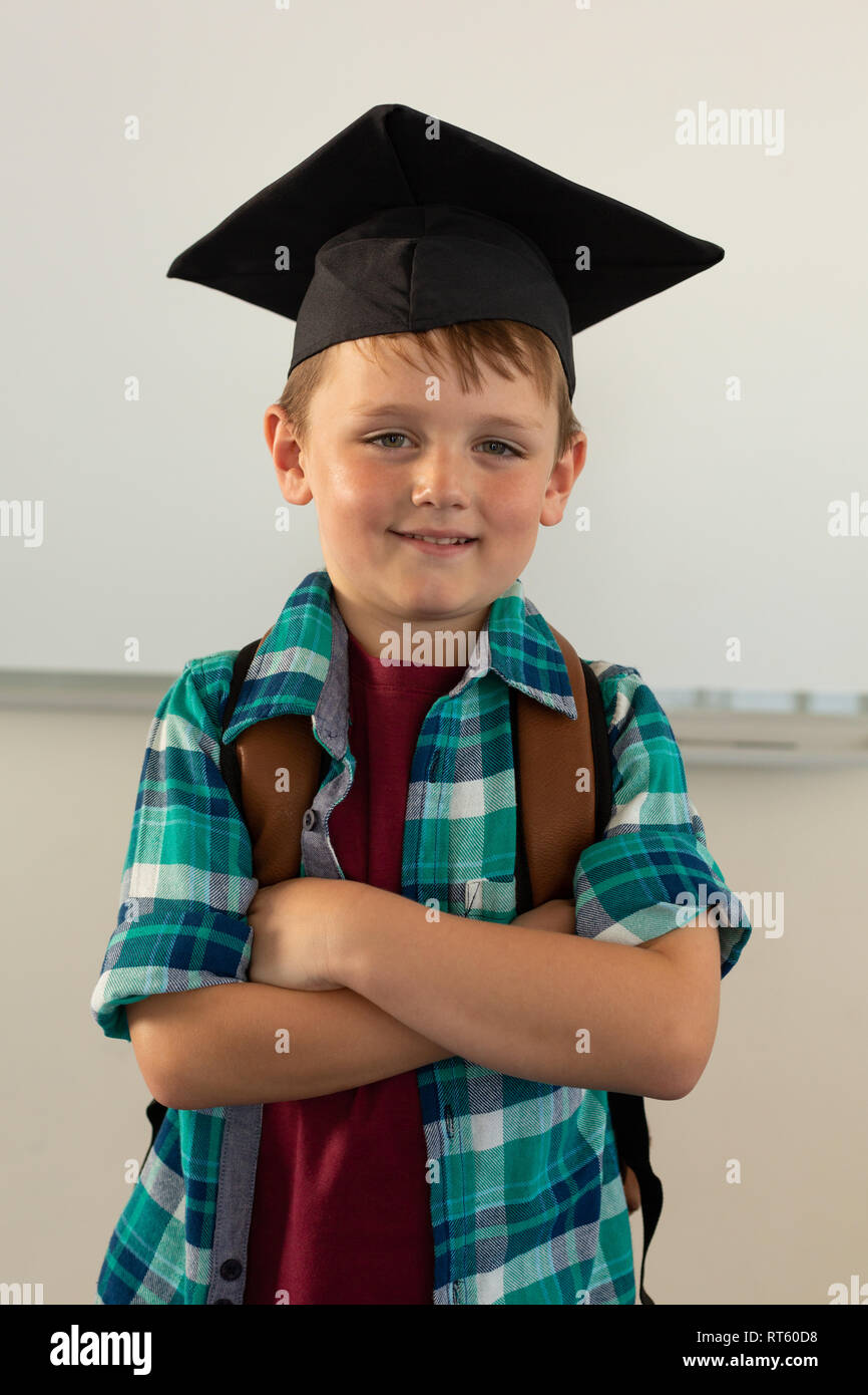 Happy boy in graduation cap standing in a classroom Stock Photo - Alamy