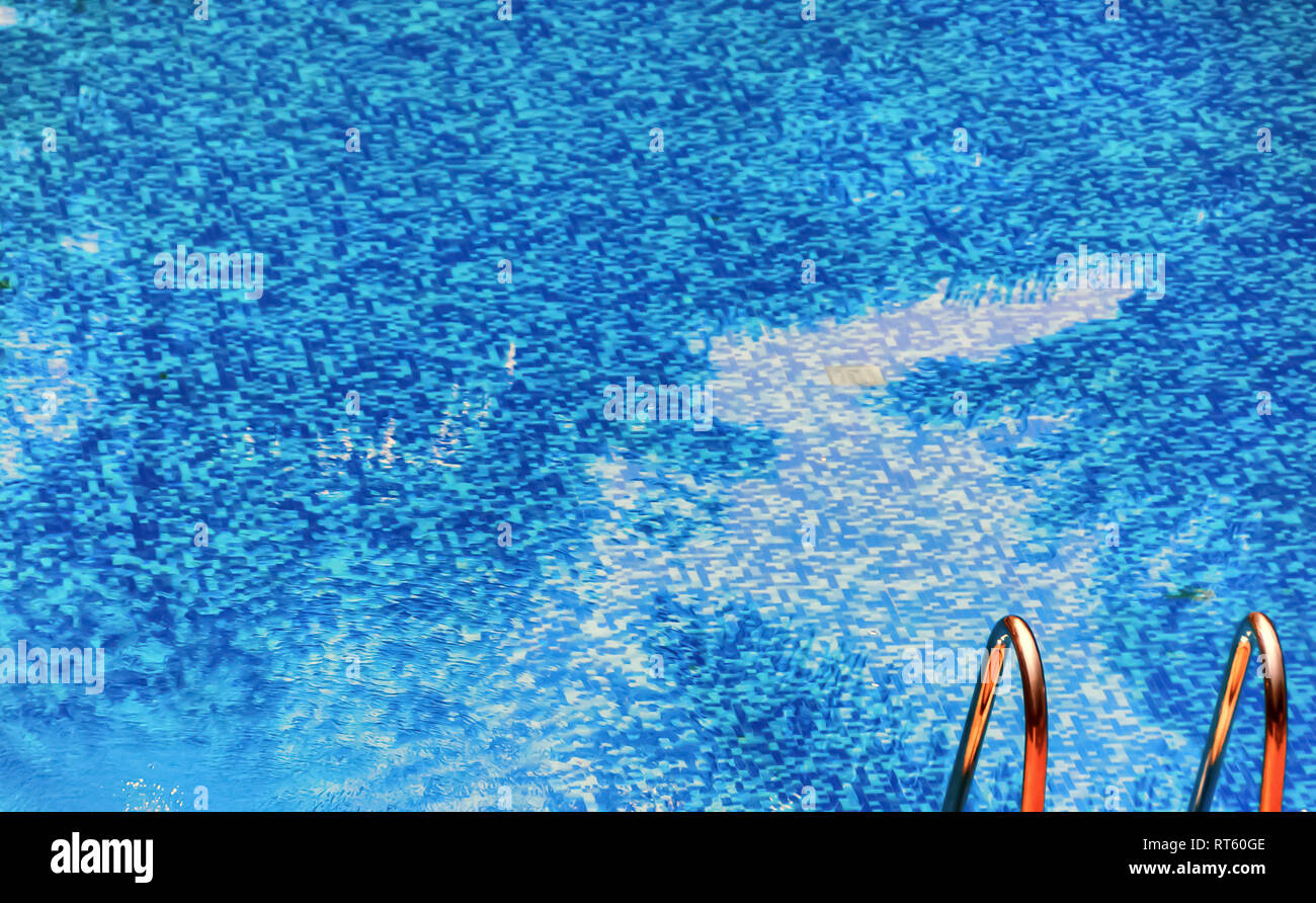 The handrail of a ladder in an empty swimming pool. Tiny bubbles and ...