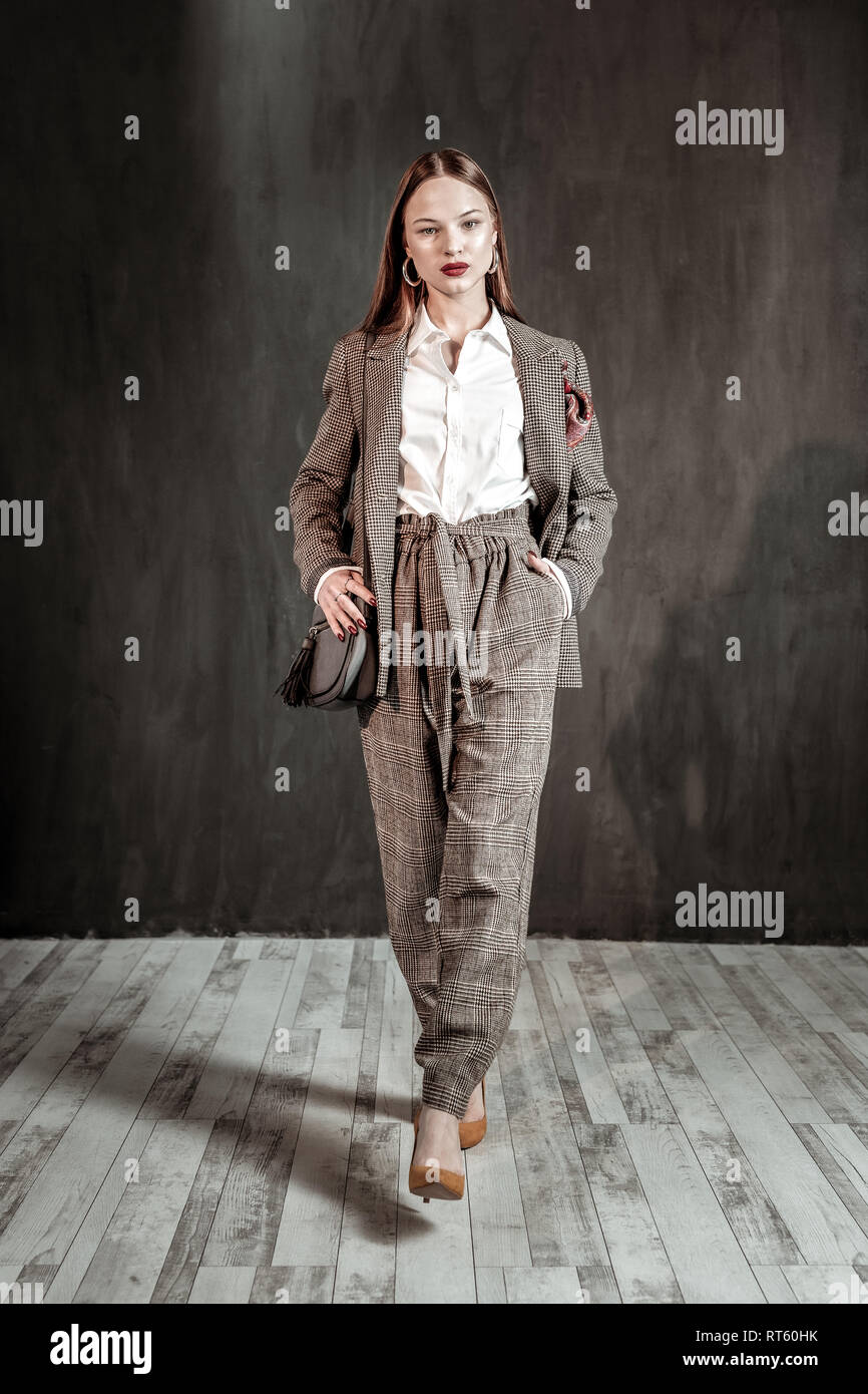 Professional studio. Attractive female person putting hand into pocket ...