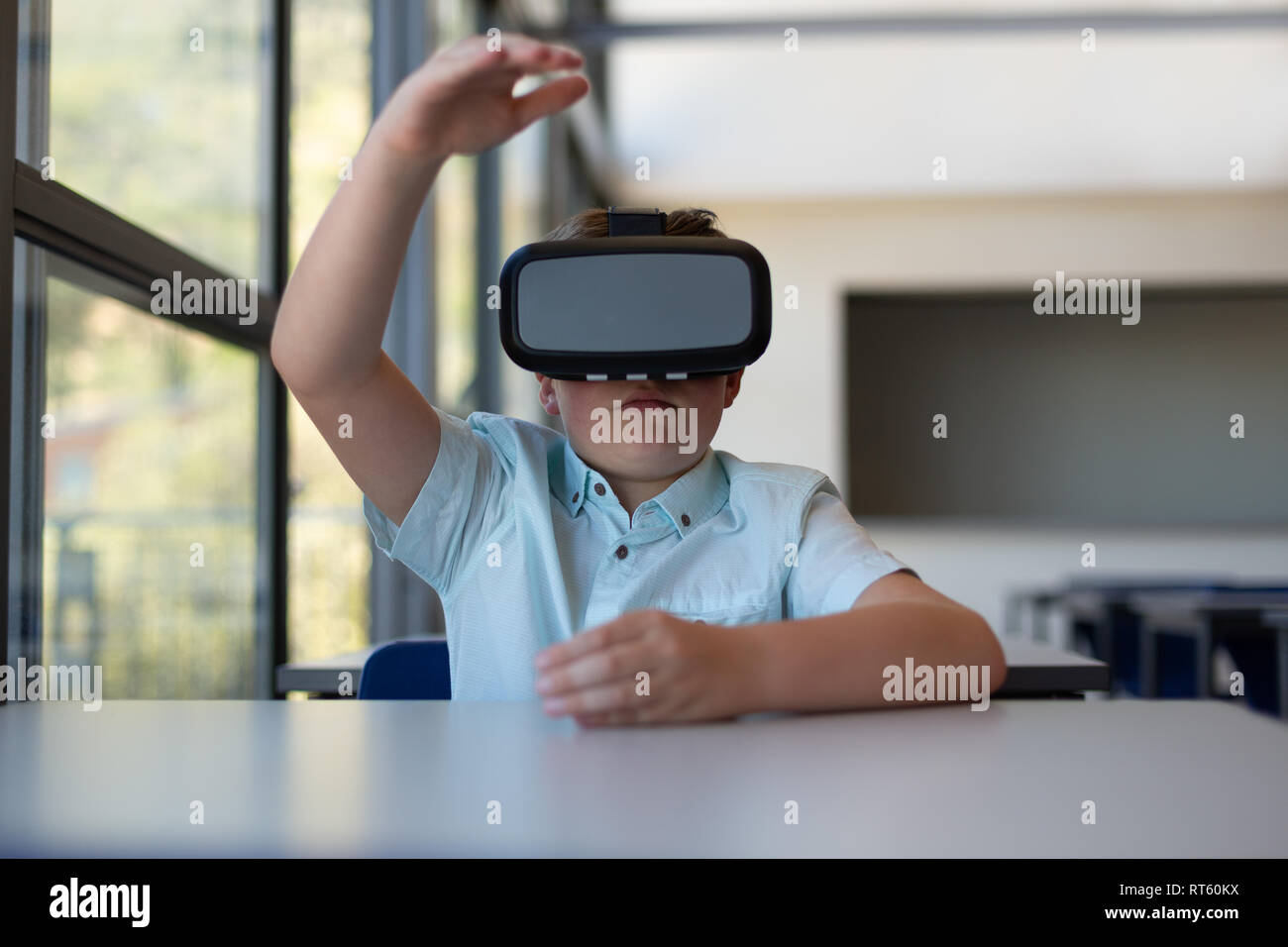 Schoolboy using virtual reality headset in a classroom Stock Photo - Alamy