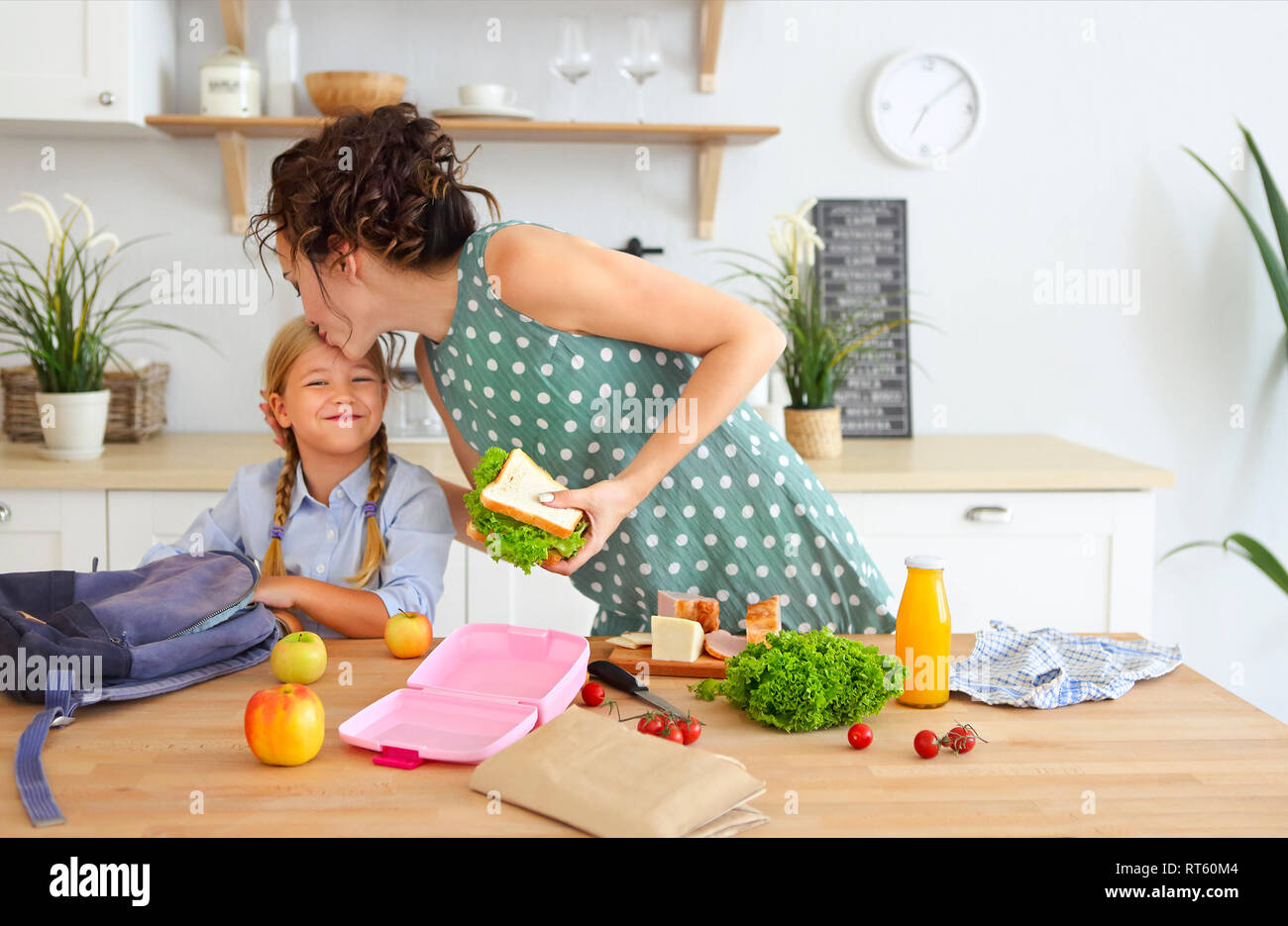 Beautiful brunette mother and her daughter packing healthy lunch and ...
