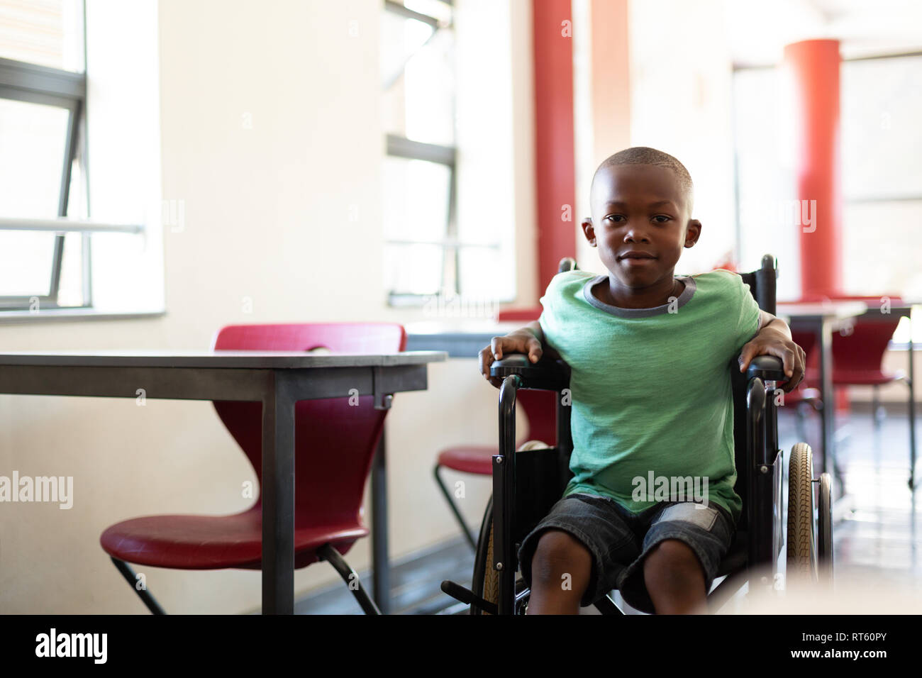 Disabled schoolboy looking at camera in a classroom Stock Photo - Alamy