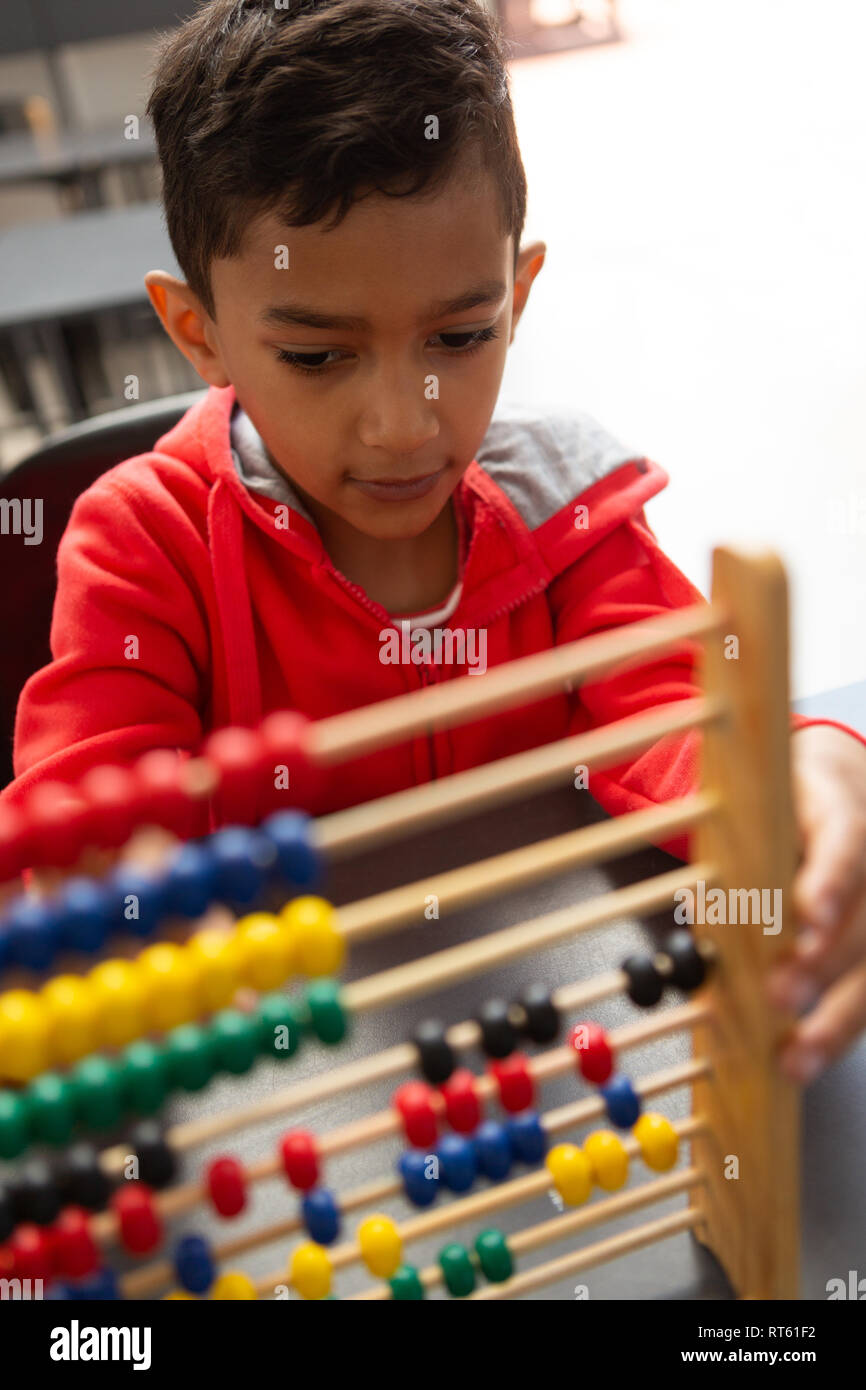 Schoolboy learning math with abacus at desk in a classroom Stock Photo ...