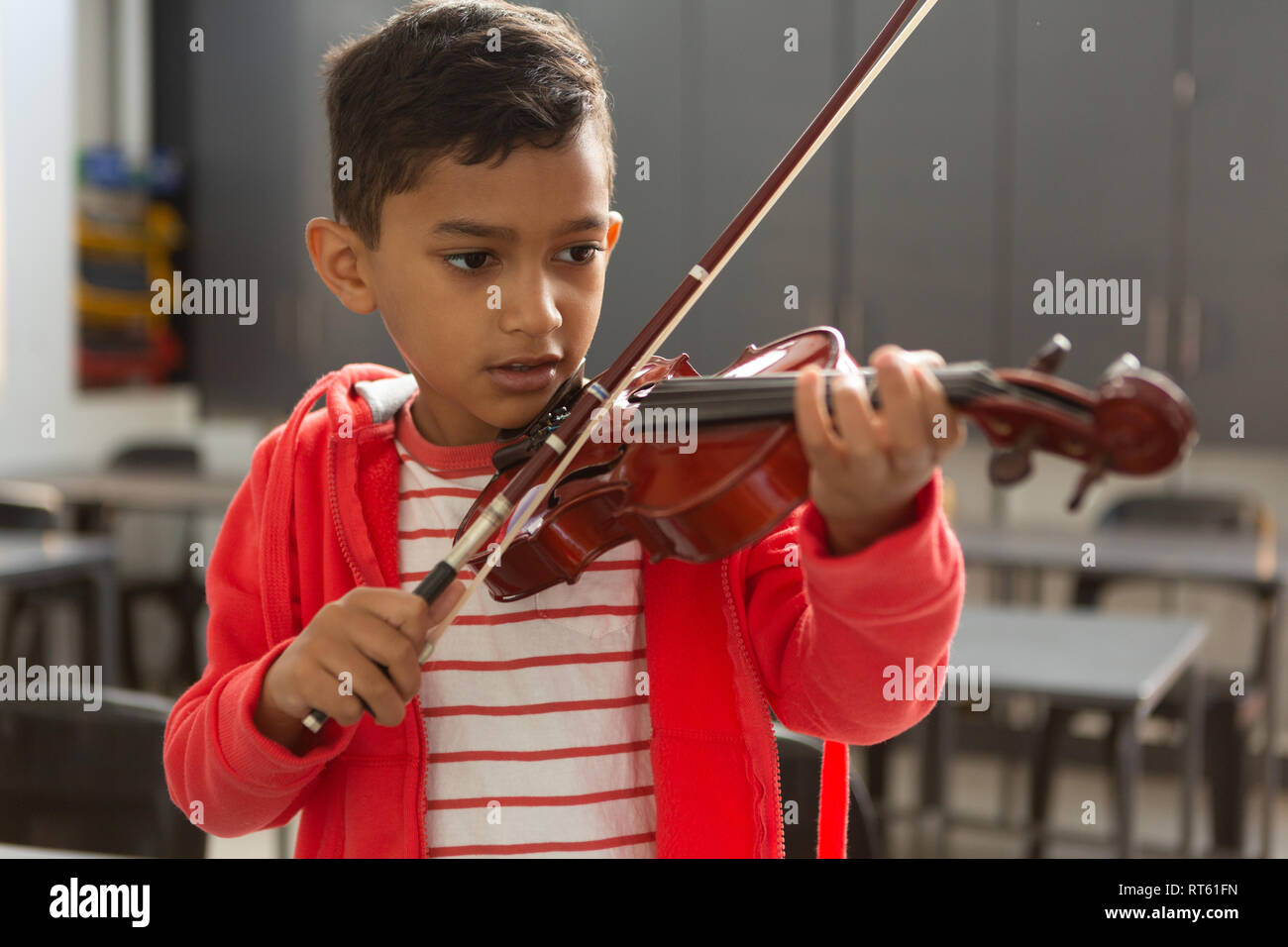 Schoolboy playing violin in classroom Stock Photo - Alamy