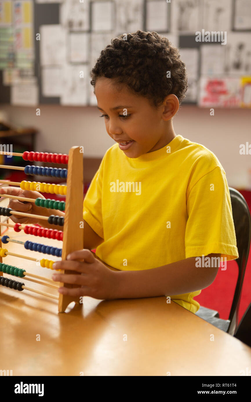Schoolboy learning mathematics with abacus in a classroom Stock Photo ...