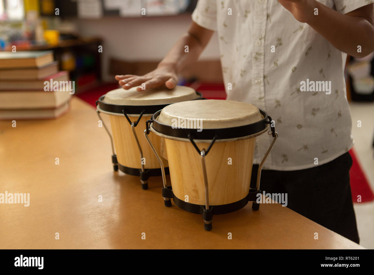 Schoolboy playing bongo in a classroom Stock Photo - Alamy
