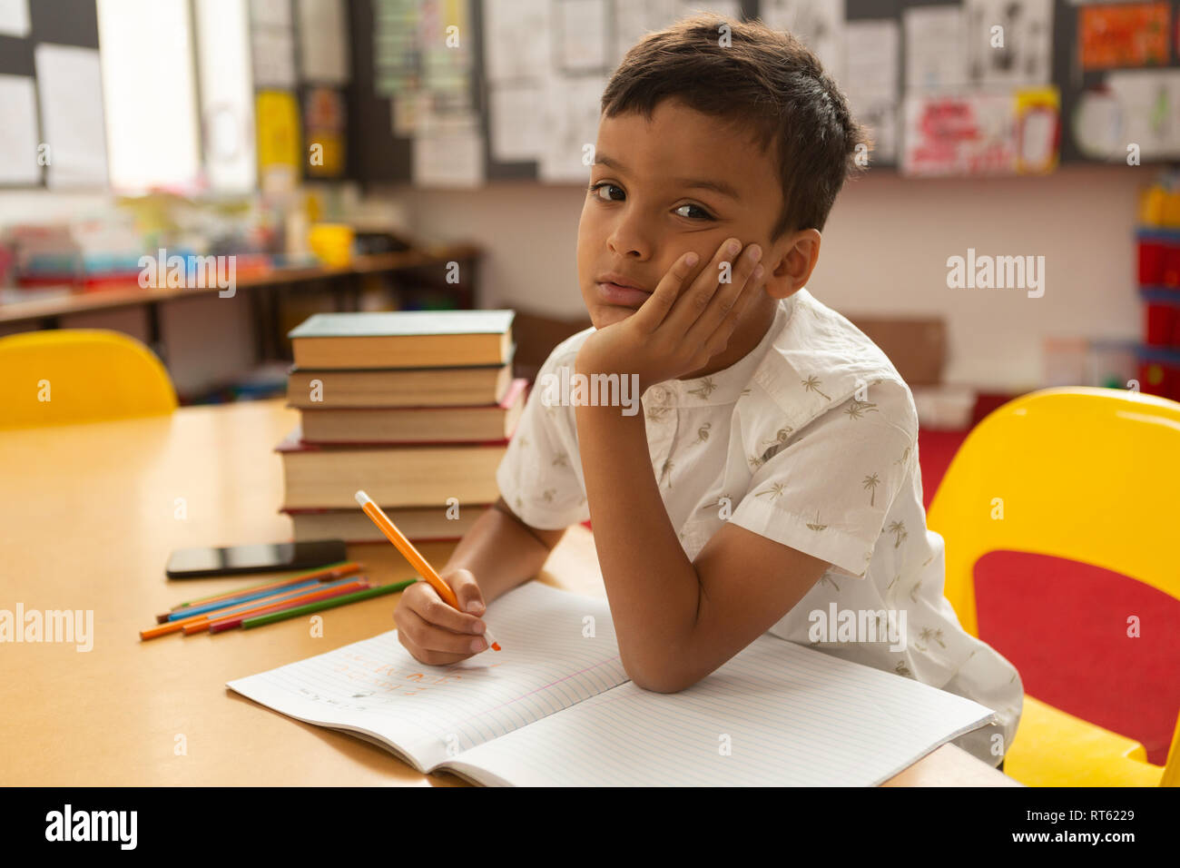 Schoolboy studying at table in a classroom Stock Photo - Alamy