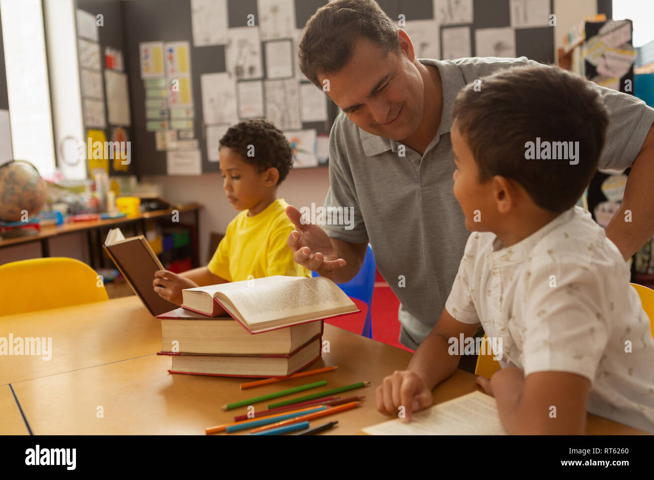 Male teacher teaching a schoolboy in a classroom Stock Photo - Alamy