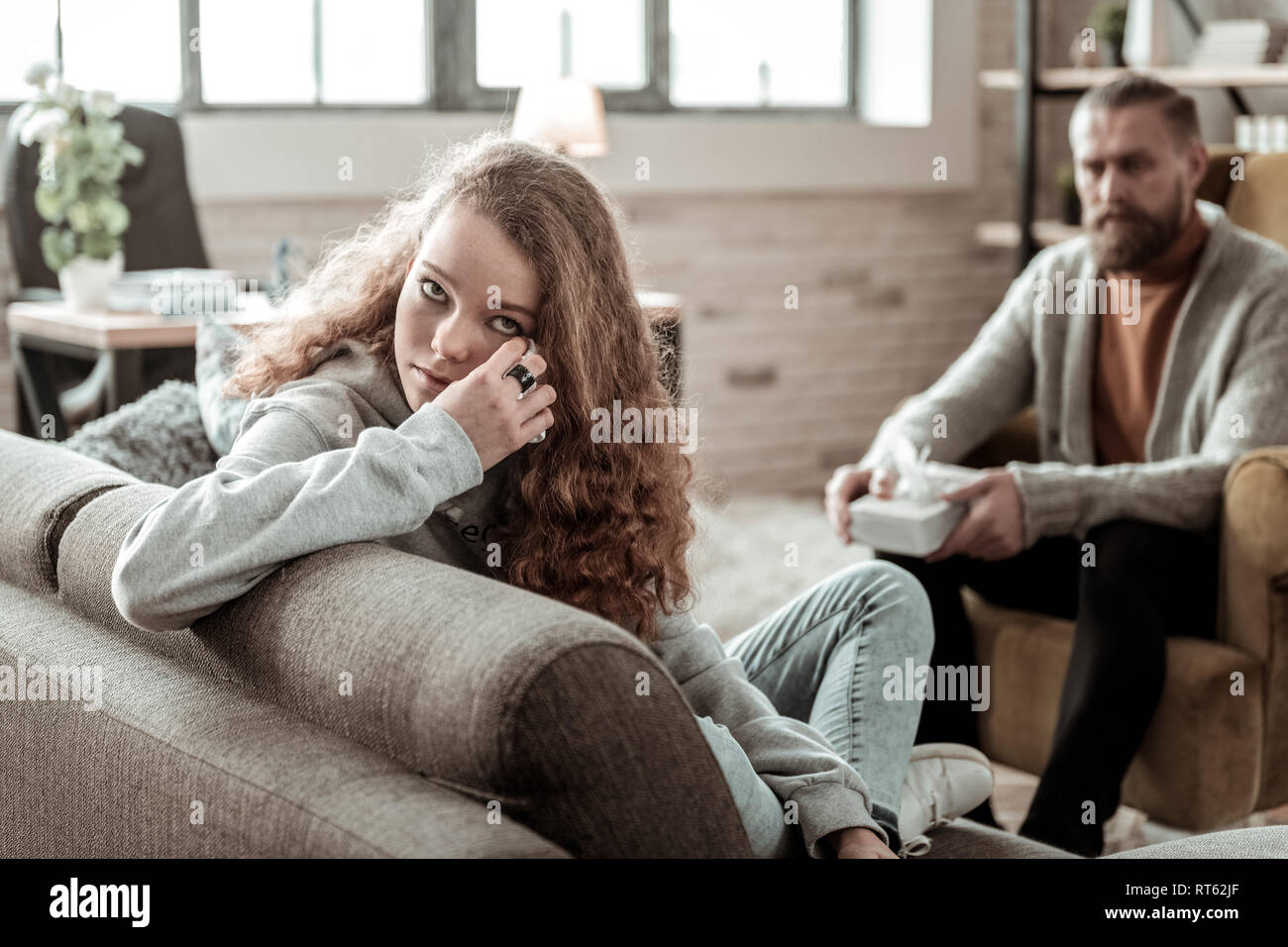 Drying tears. Curly teenage girl having deep depression drying her ...