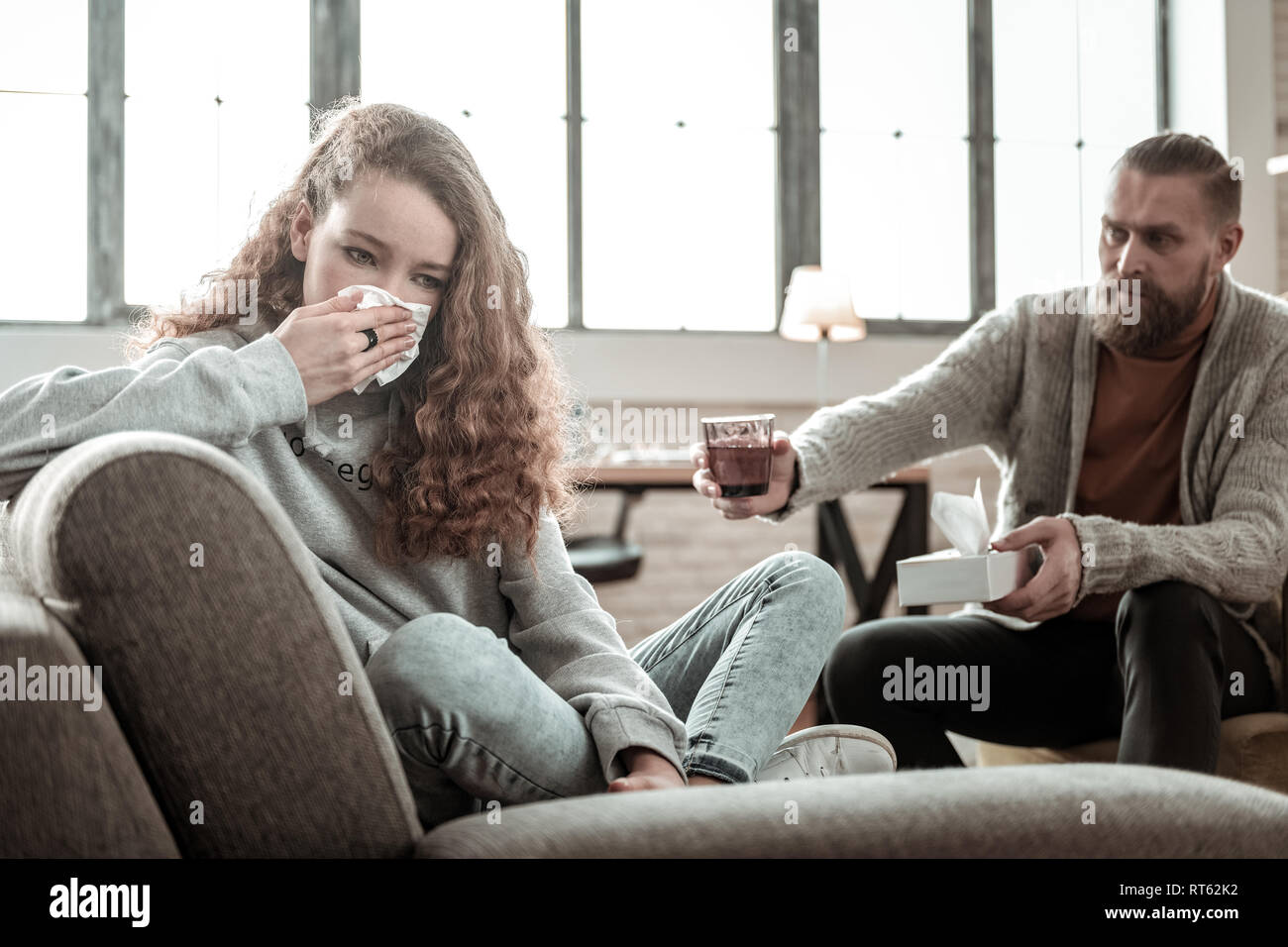 Giving water. Caring bearded therapist giving glass of water to girl ...