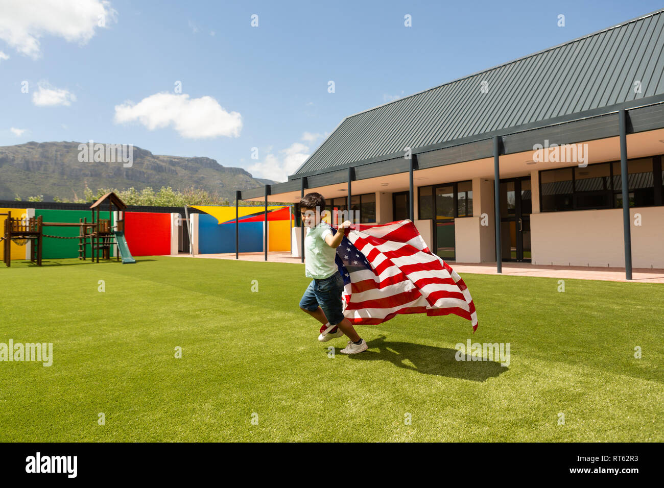 Schoolboy running with an American flag in the school playground Stock ...