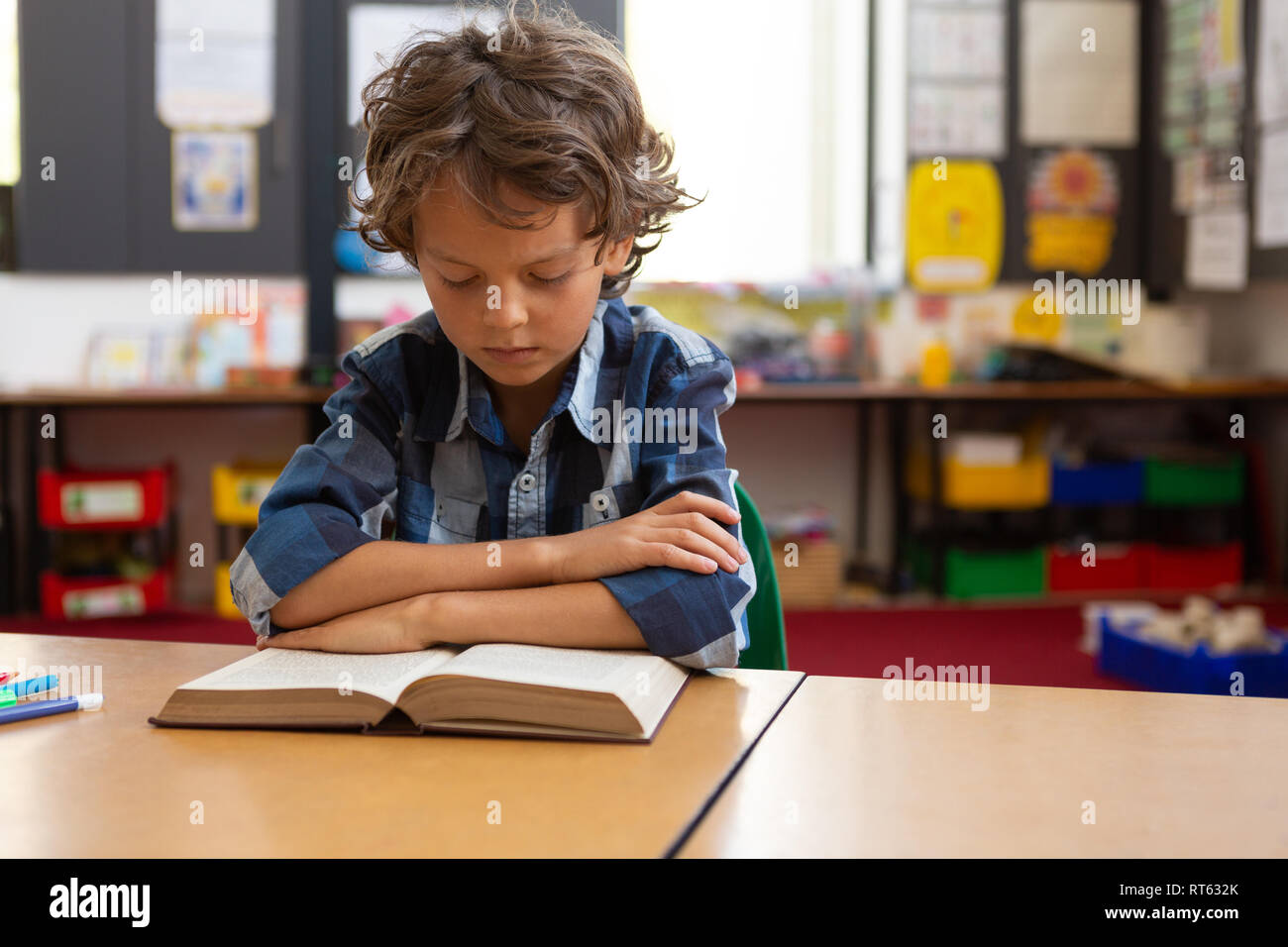 Schoolboy reading a book in the classroom Stock Photo - Alamy