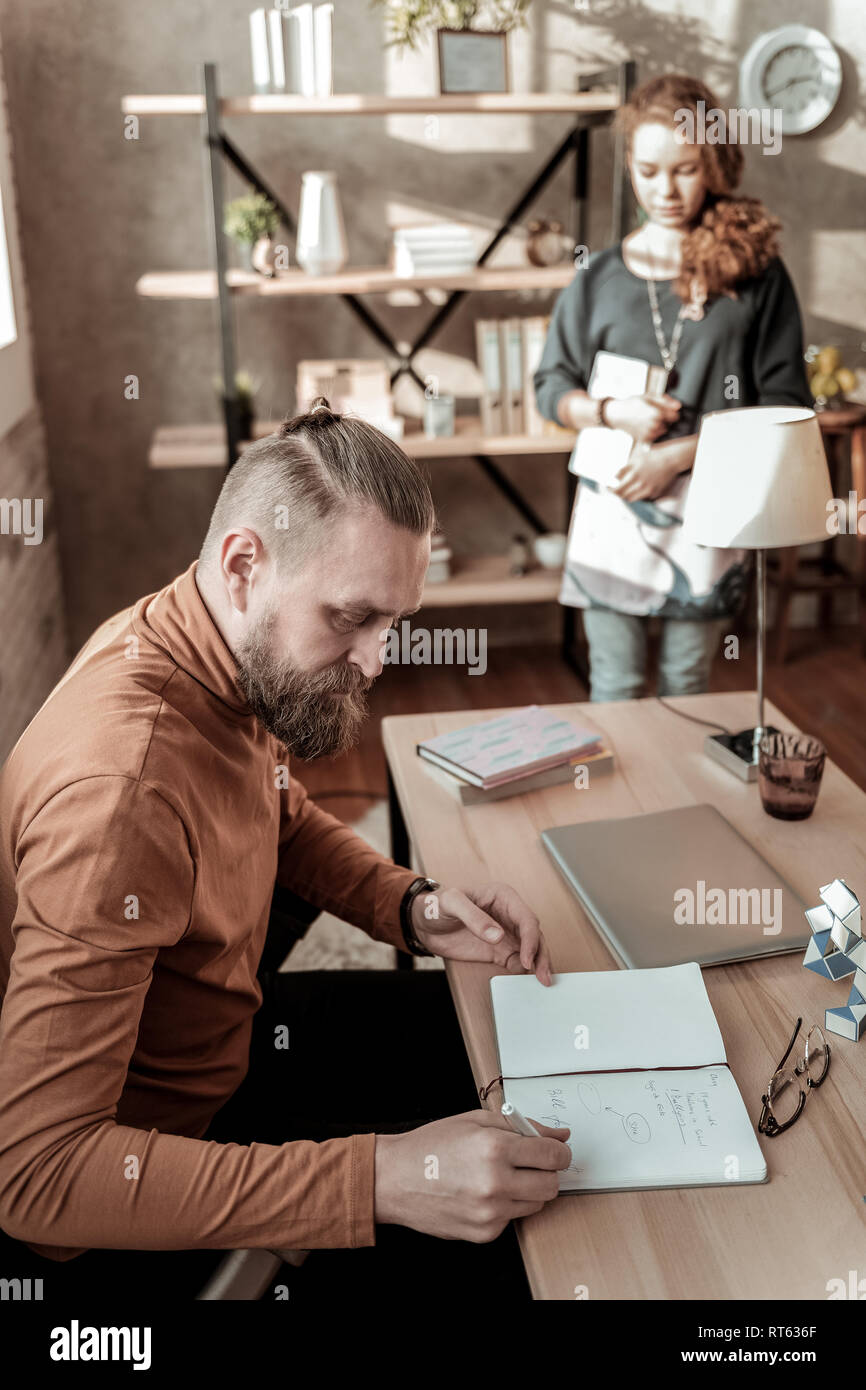 Father feeling busy. Top view of father feeling busy making notes while ...
