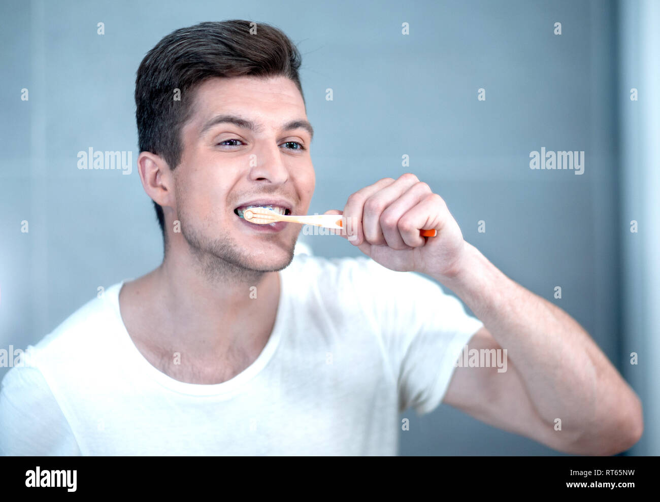 young man brushing his teeth in the bathroom Stock Photo - Alamy
