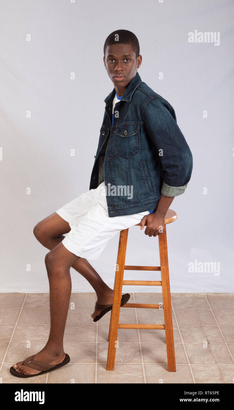 Handsome black man sitting thoughtfully Stock Photo - Alamy
