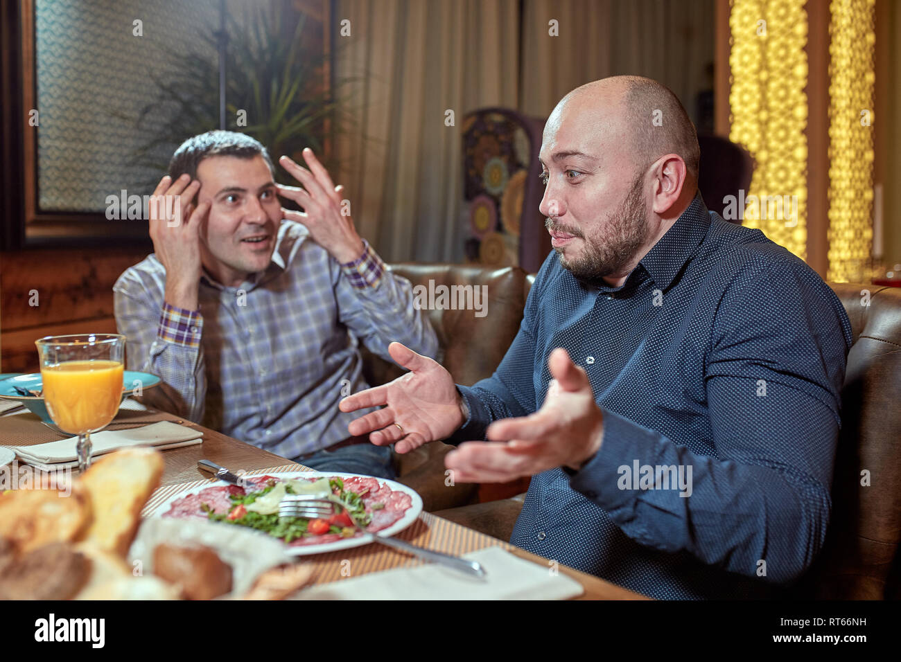 two men in a restaurant arguing during lunch Stock Photo - Alamy
