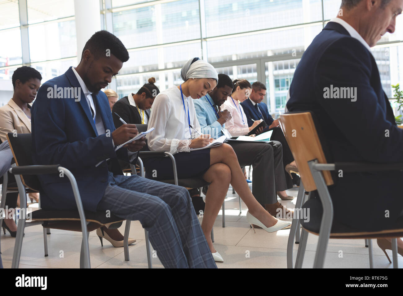 Business people writing on notepad during seminar Stock Photo - Alamy