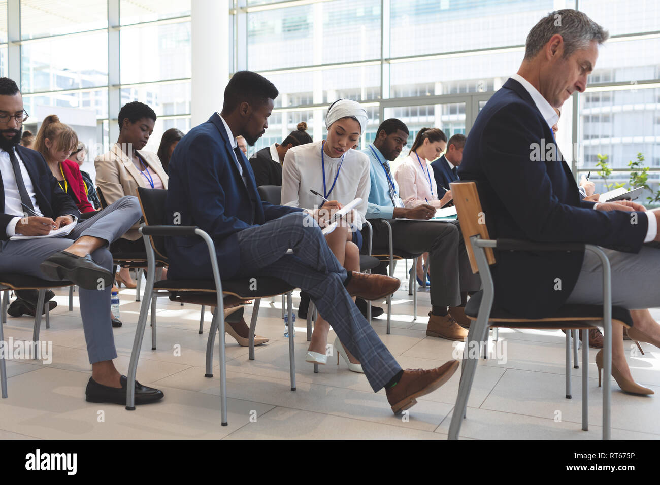 Business people writing on notepad during seminar Stock Photo - Alamy