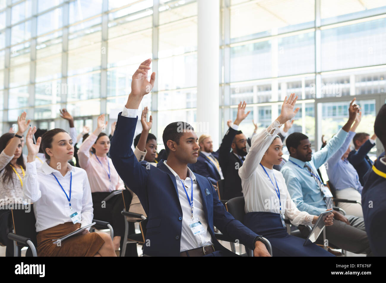 Business people raising hands in business seminar Stock Photo - Alamy