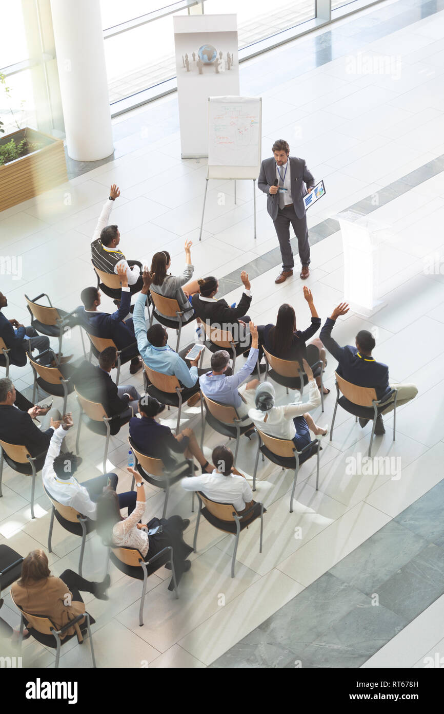 Group of diverse business people raising their hands to ask questions ...